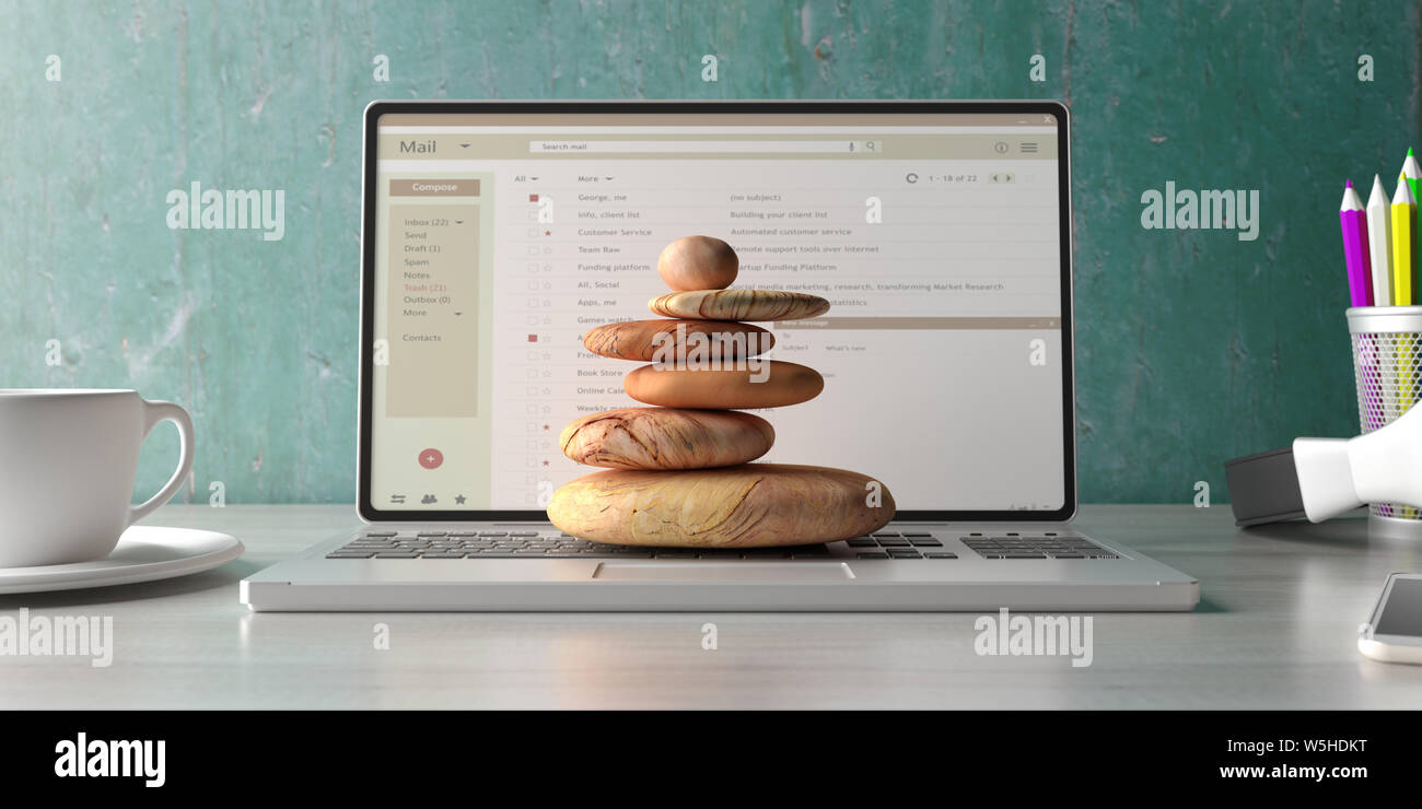 Zen stones stack on a computer laptop office desk background. Relax and ...