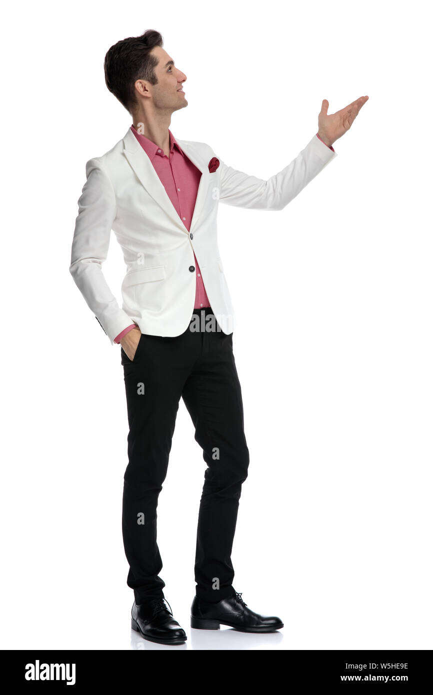 side view of a young elegant man showing something up on white ...