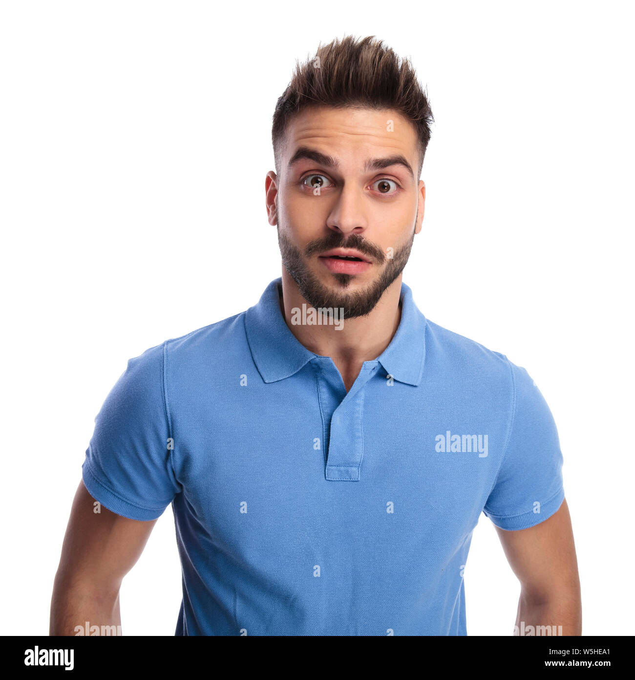 Confused man wearing a light blue polo being surprised while looking at ...