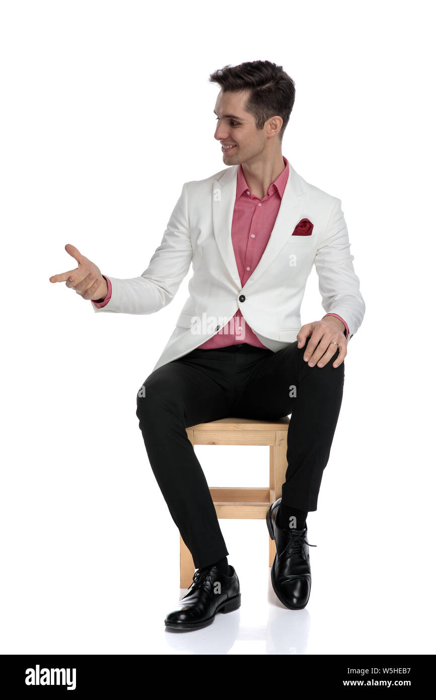 seated young man talking with someone besides him and he gesticulates ...