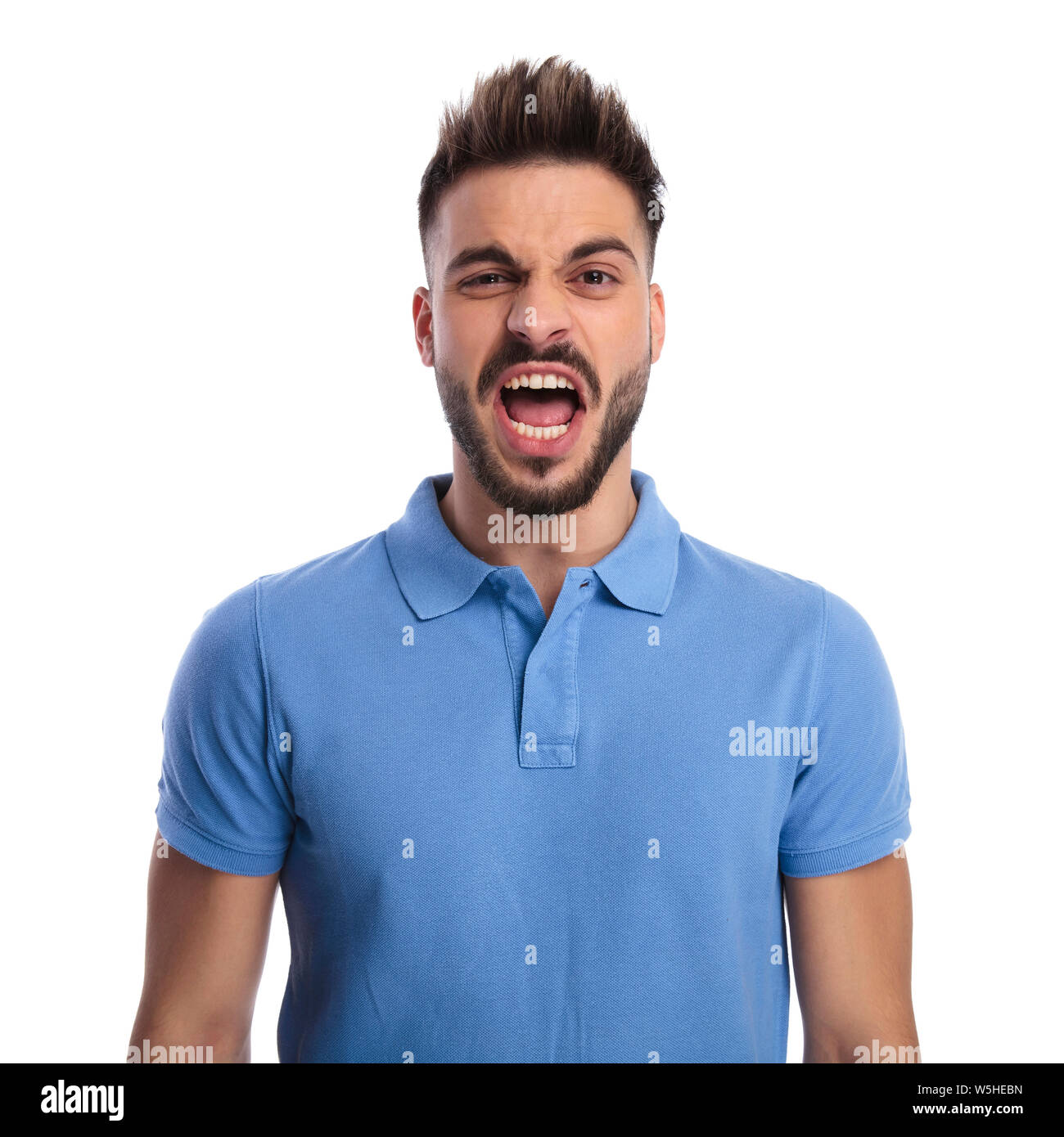 Young man wearing a light blue polo shouting out loud while looking at ...