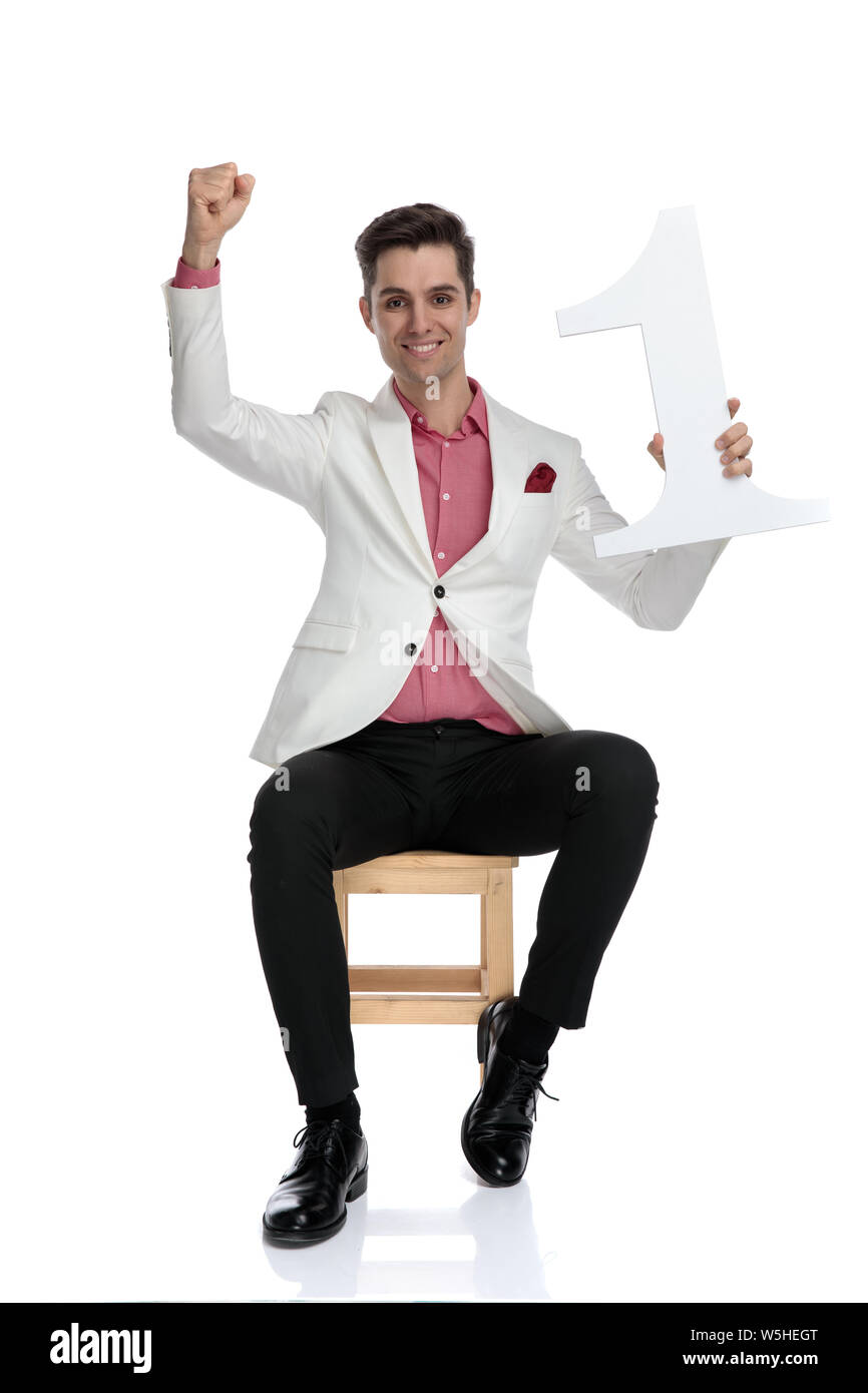 seated elegant man celebrating being number on with hands in the air on ...