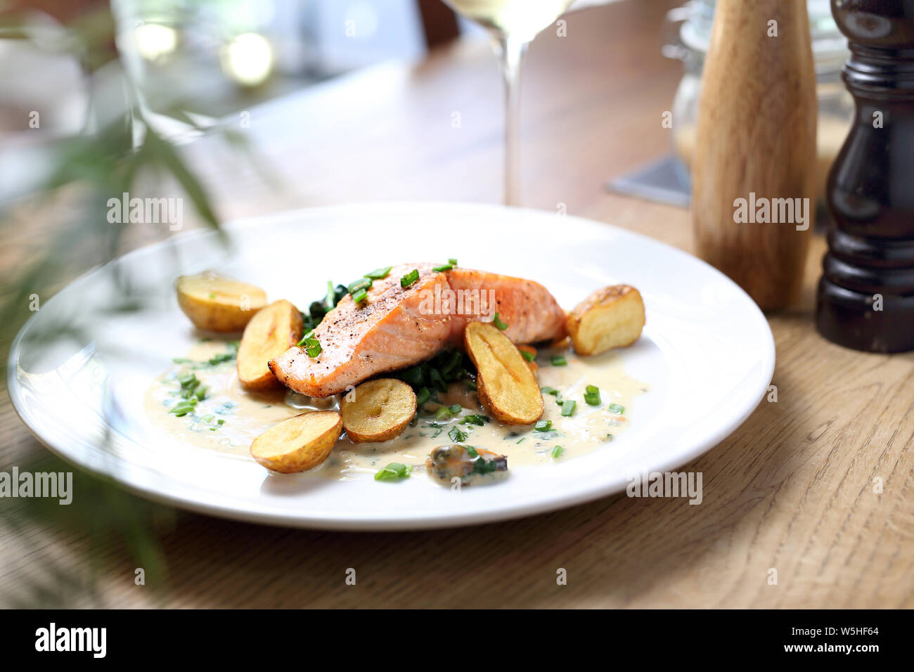 Elegant, exquisite dinner dish served on white plates with a glass of ...