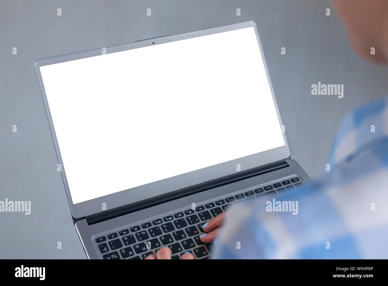 Woman student typing on grey laptop computer keyboard with white blank ...