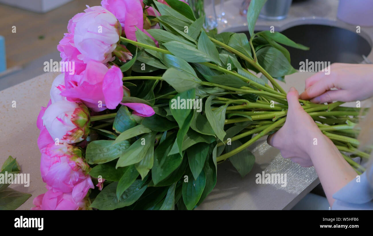 Florist woman making bunch at flower shop Stock Photo - Alamy