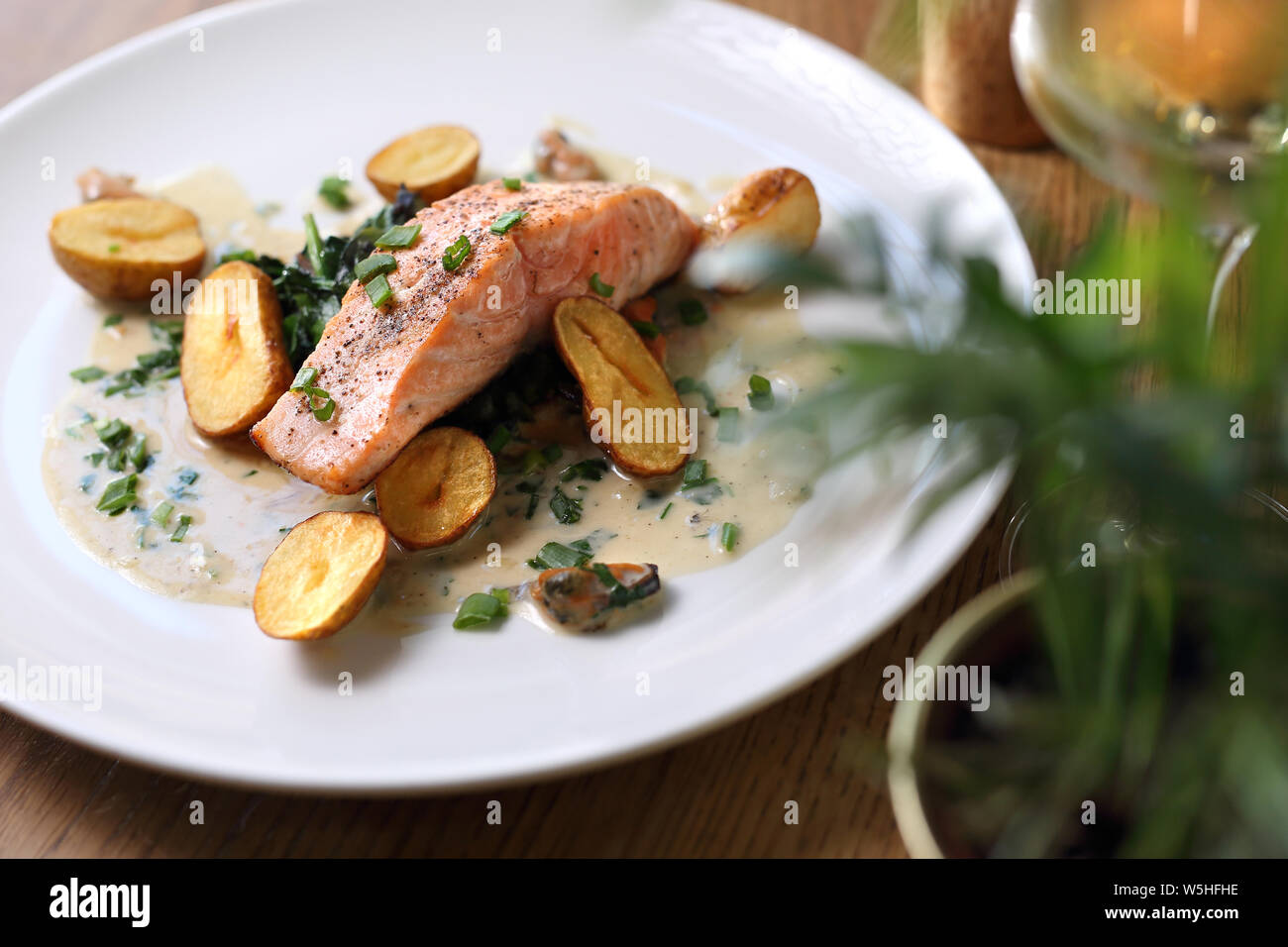 Elegant, exquisite dinner dish served on white plates with a glass of ...