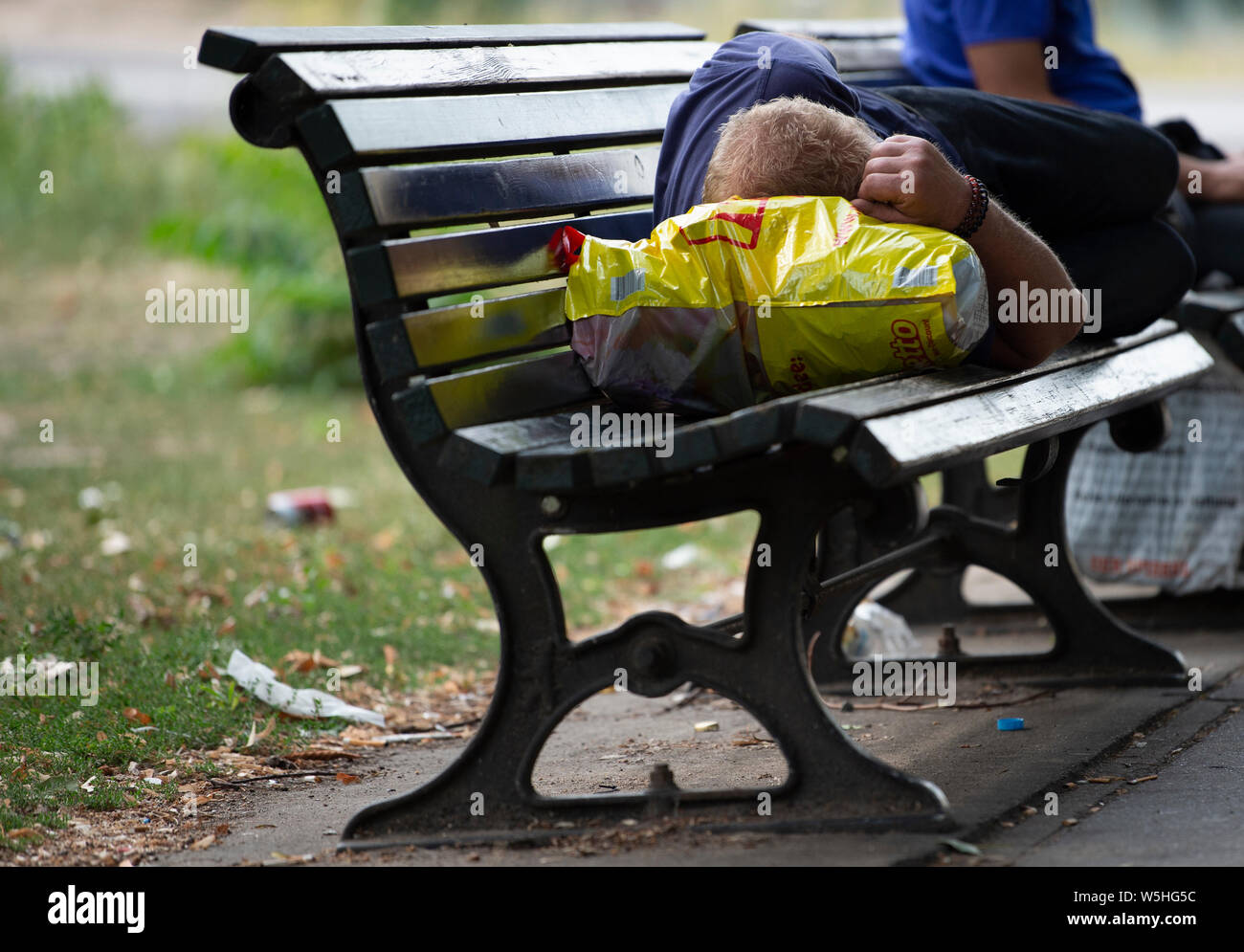 Berlin, Germany. 29th July, 2019. A homeless man lies under a tree on a ...