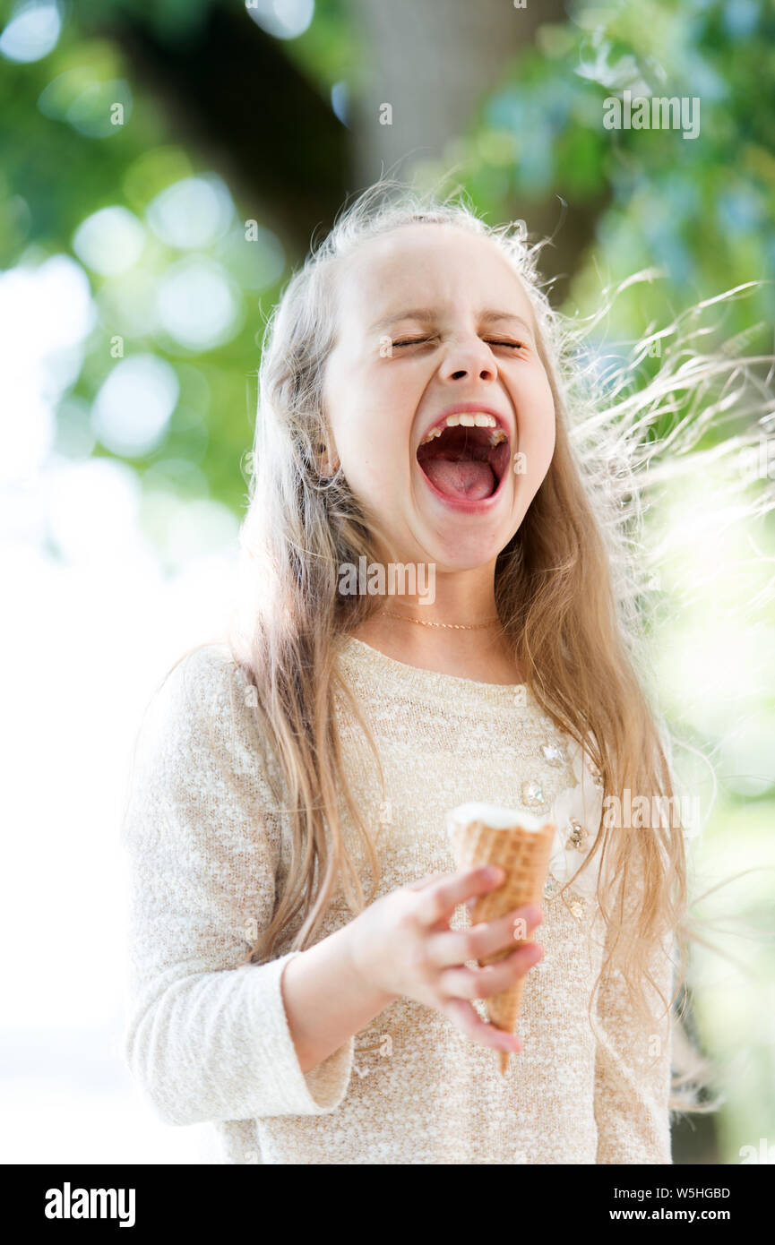 Ice cream makes her fall into euphoria. Cute little girl eating ice ...