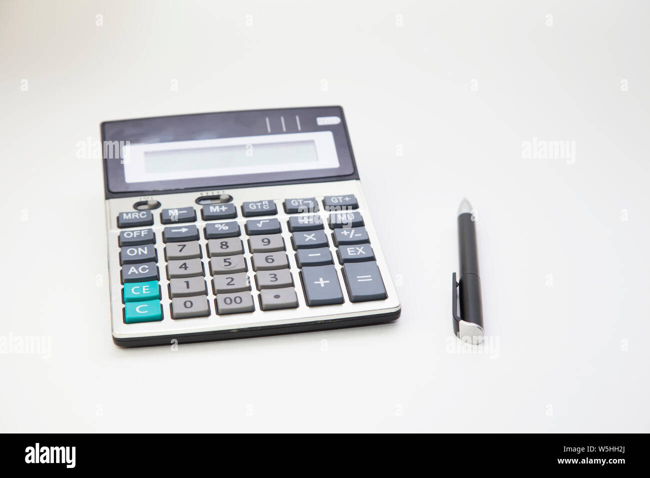 Calculator and pen isolated on white background Stock Photo - Alamy