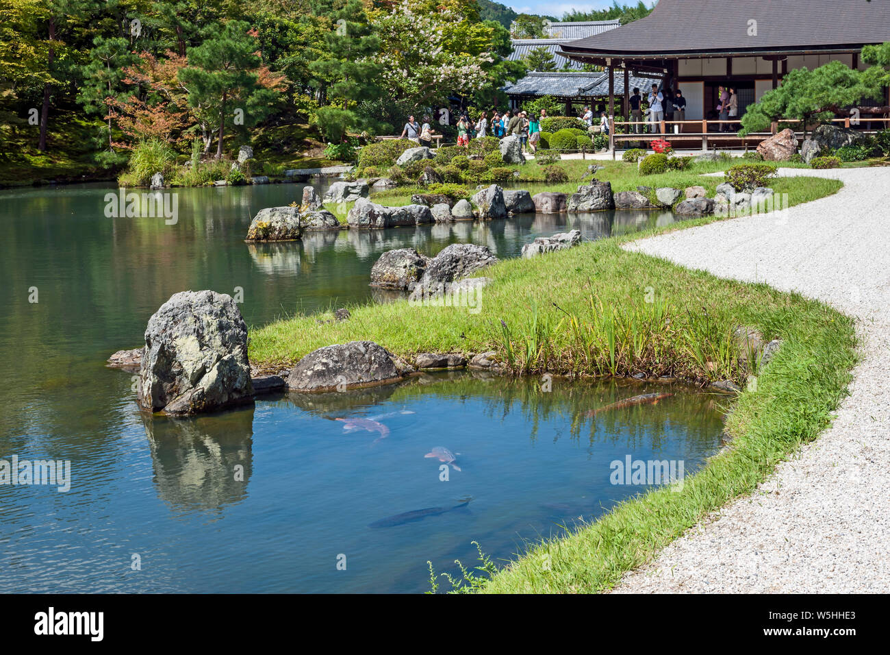 The Sogen ornamental pond with path to one side. Background of temple ...