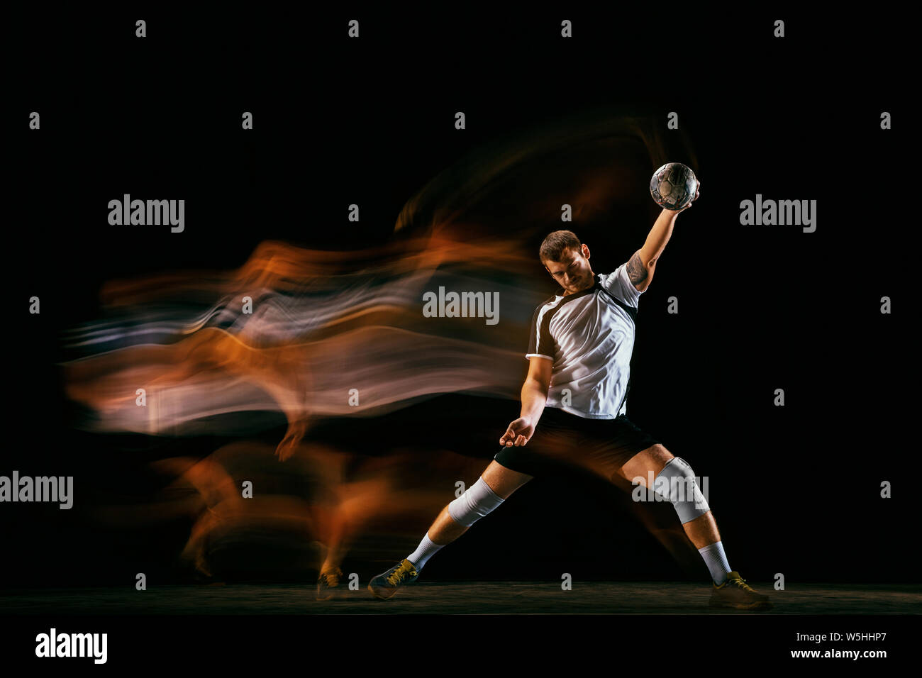 Caucasian young handball player in action and motion in mixed lights ...