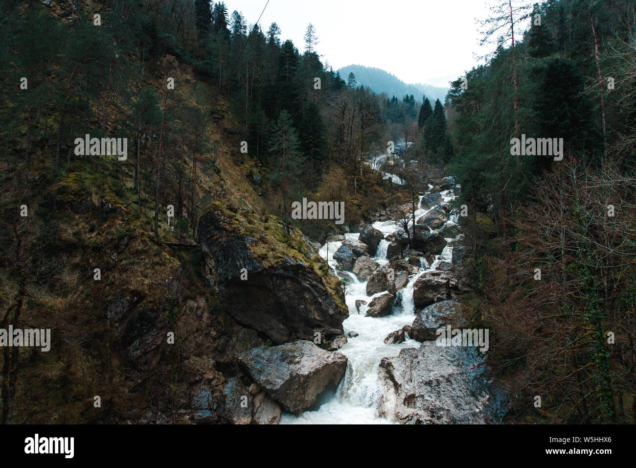 Small cliffy mountain spring waterfall in Abkhazia. Craggy ridge cliff ...