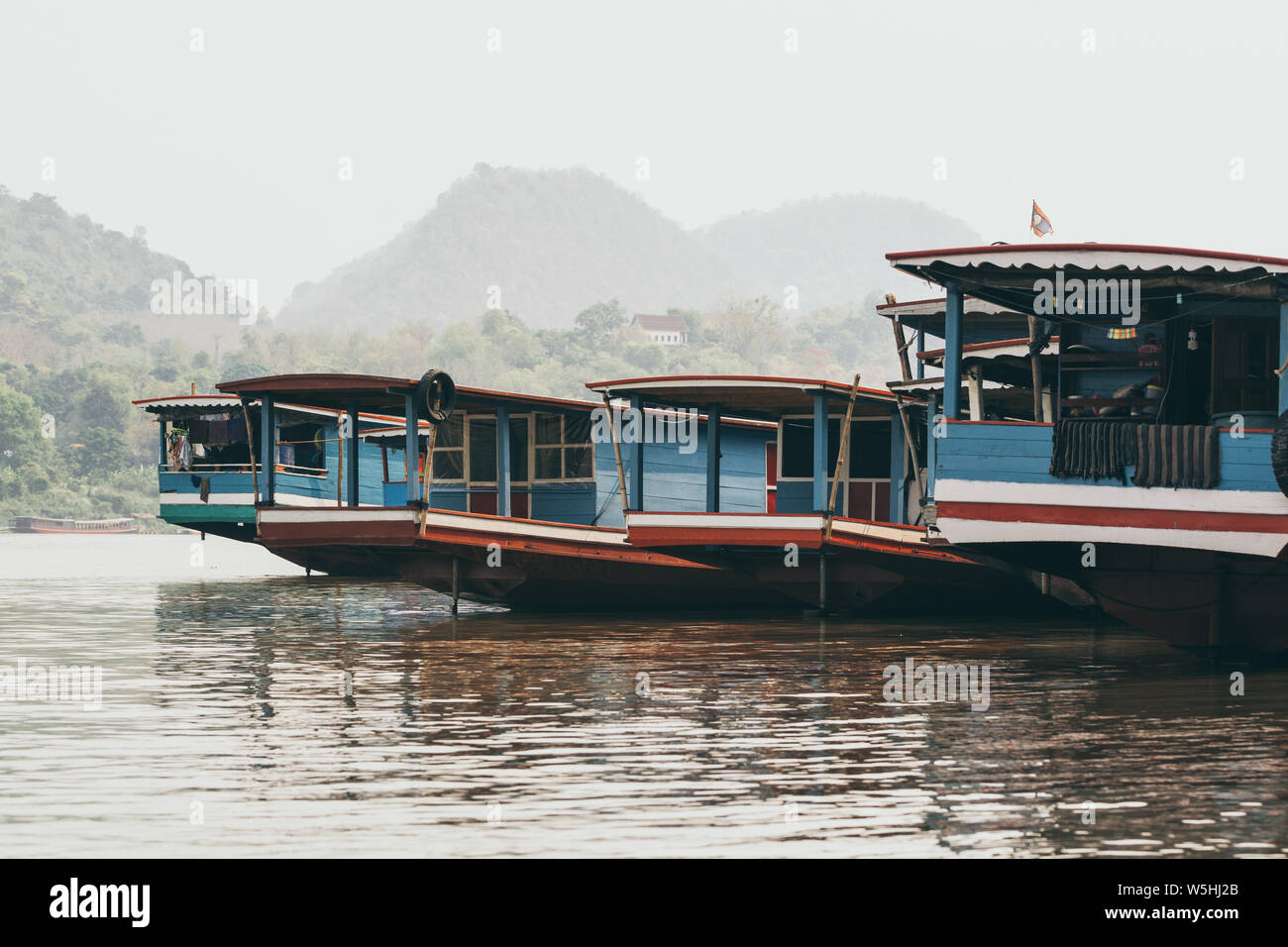 Traditional Laotian wooden slow boats on Mekong river near Luang ...