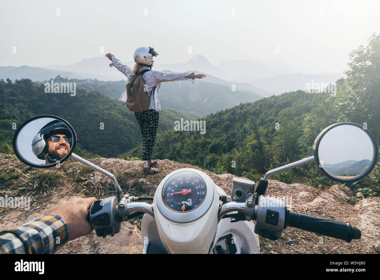 Young Caucasian couple riding a motorcycle in Laotian mountains. Woman ...
