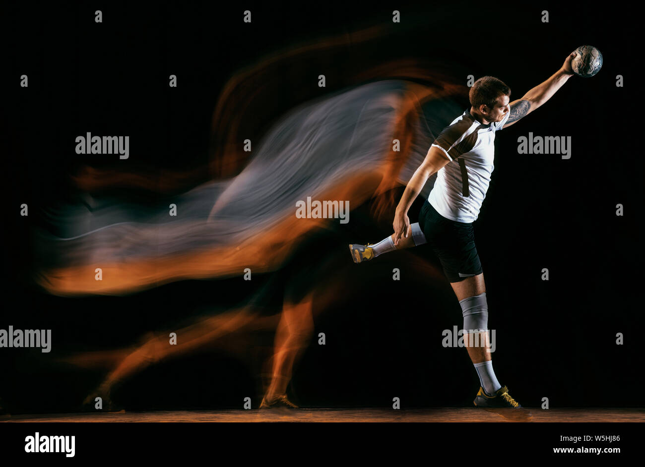 Caucasian young handball player in action and motion in mixed lights ...