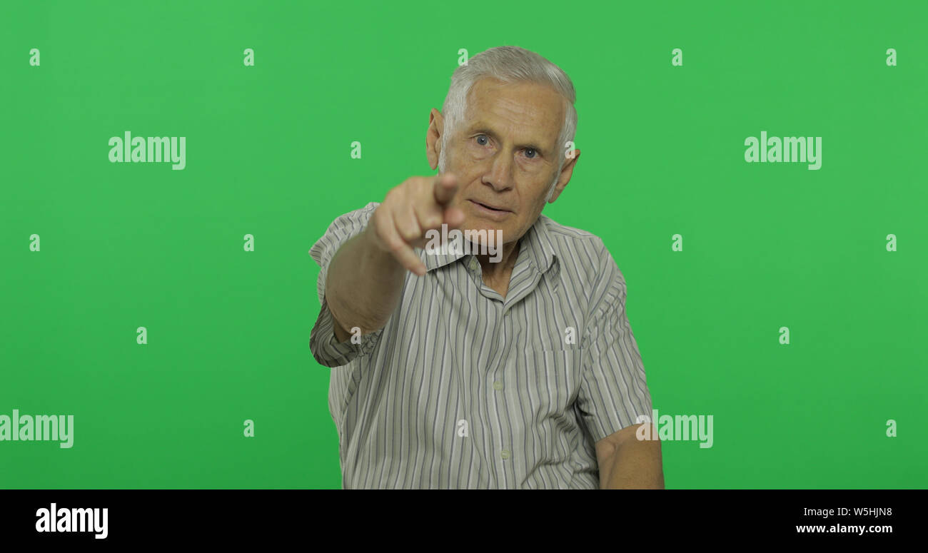 Senior man points at the camera. Handsome old man on chroma key ...