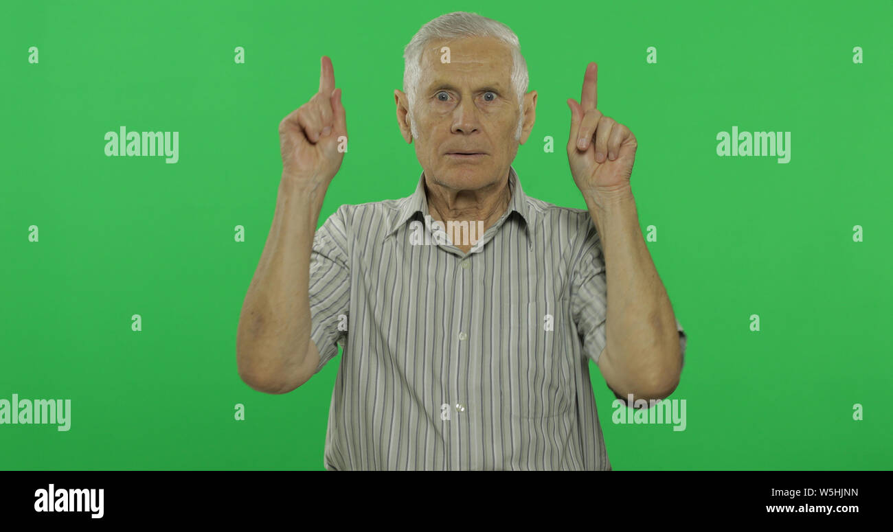 Senior man points to the top. Handsome old man on chroma key background ...