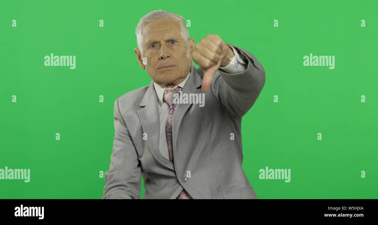 Elderly businessman giving thumb down. Old man in formal wear showing ...