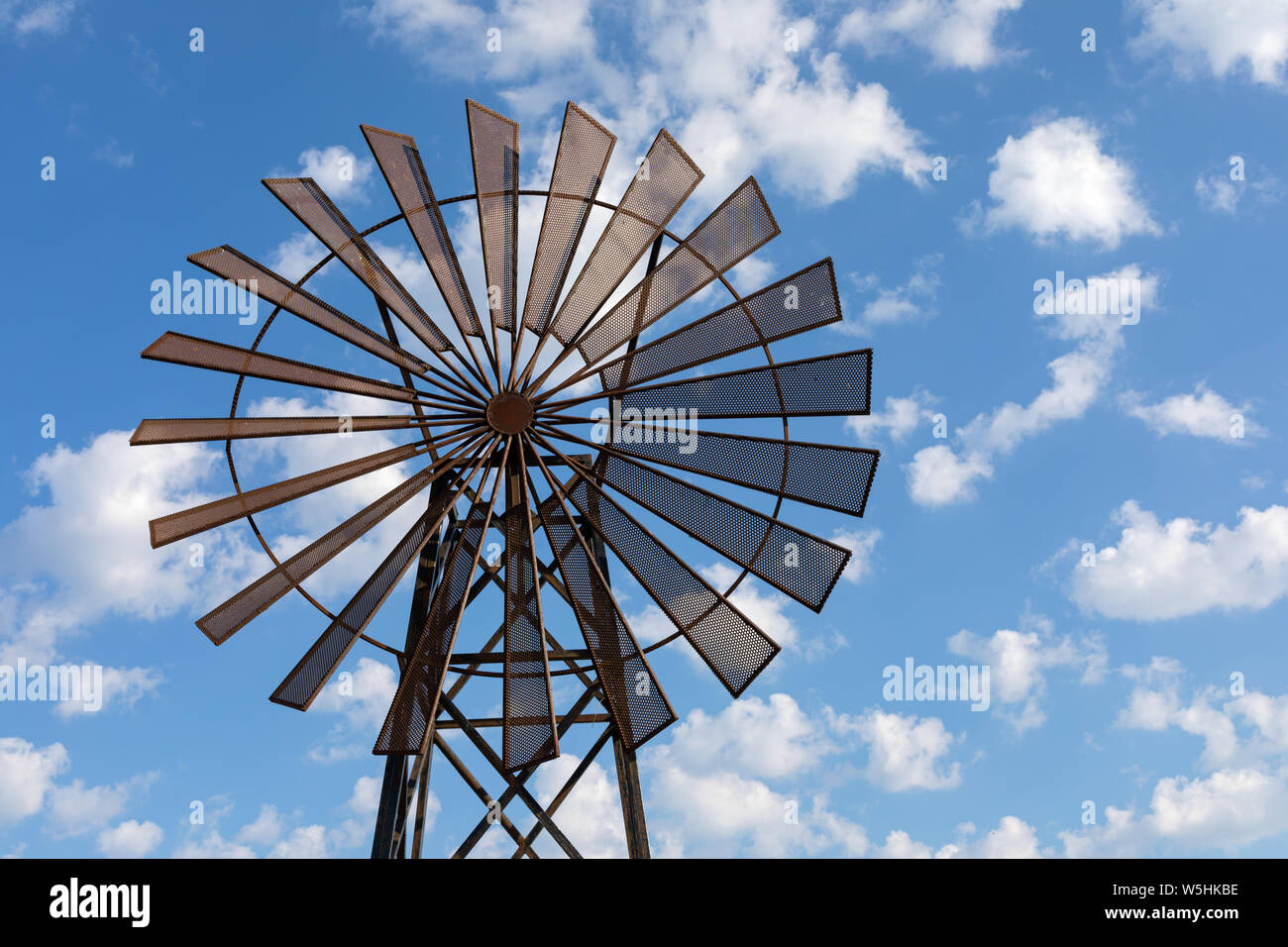 Circular windmill against blue cloudy sky - energy production Stock ...