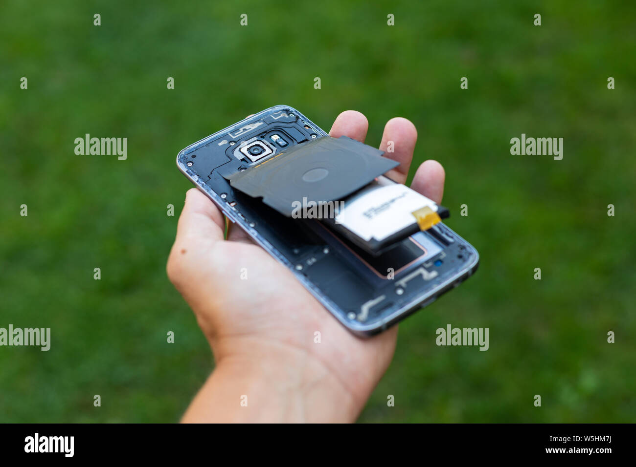 Close up of a damaged smartphone with expanded lithium ion battery ...