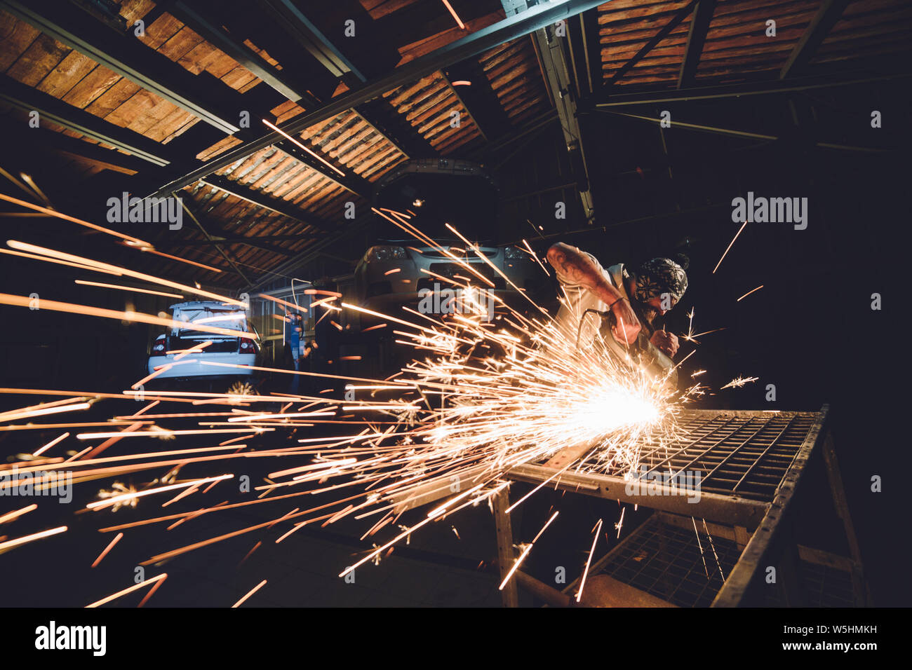 The employee of the service station produces body repair with a welding ...