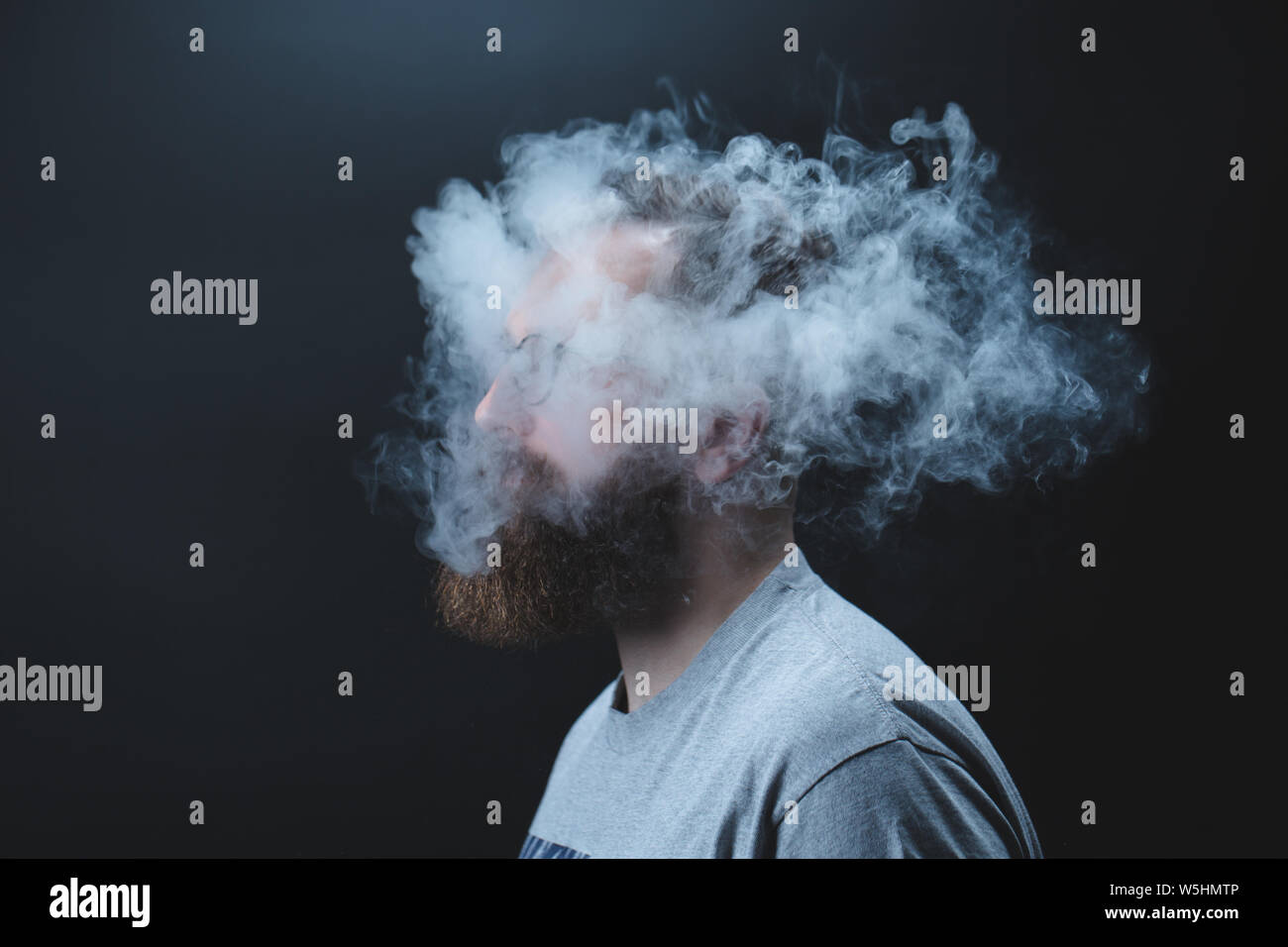 Concept. Smoke enveloped the head man. Portrait of a Bearded, stylish ...