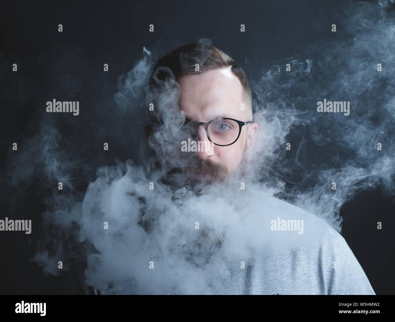 Concept. Smoke enveloped the head man. Portrait of a Bearded, stylish ...