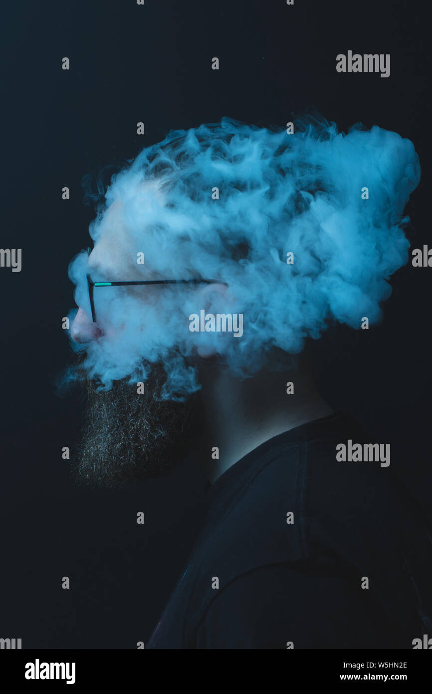Concept. Smoke enveloped the head man. Portrait of a Bearded, stylish ...