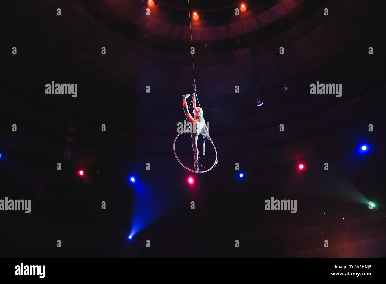 Aerial acrobat in the ring. A young girl performs the acrobatic ...