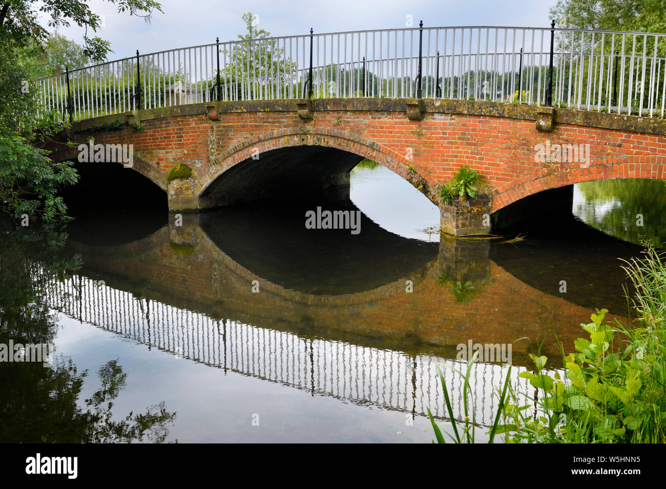 Red brick arched bridge with metal railing over the Avon river at Upper ...