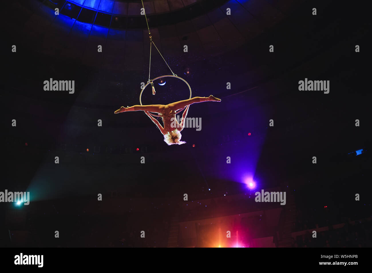 Aerial acrobat in the ring. A young girl performs the acrobatic ...