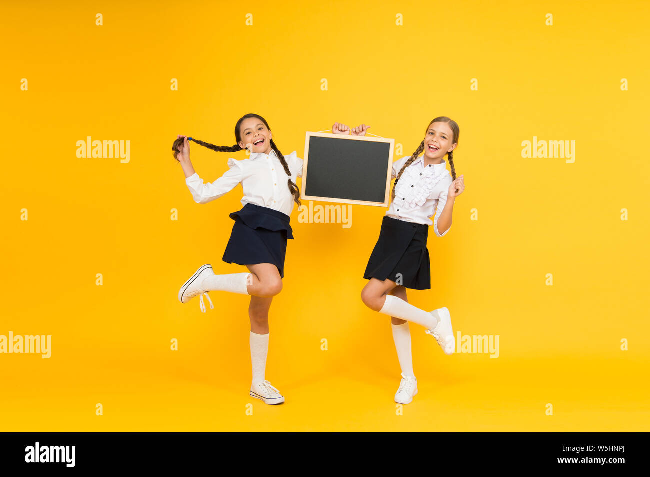 Back to school. Happy children holding school blackboard on yellow ...