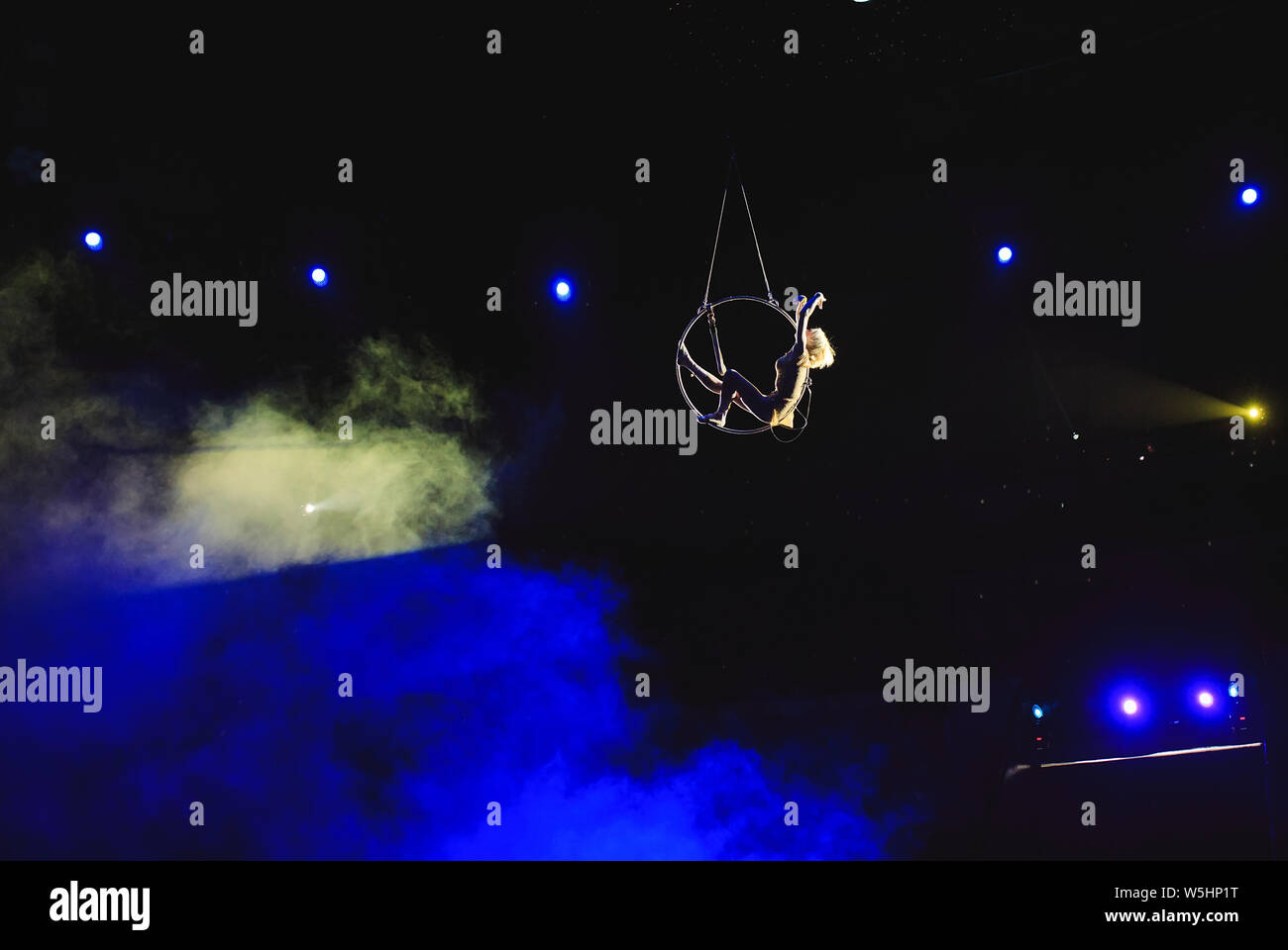 Aerial acrobat in the ring. A young girl performs the acrobatic ...