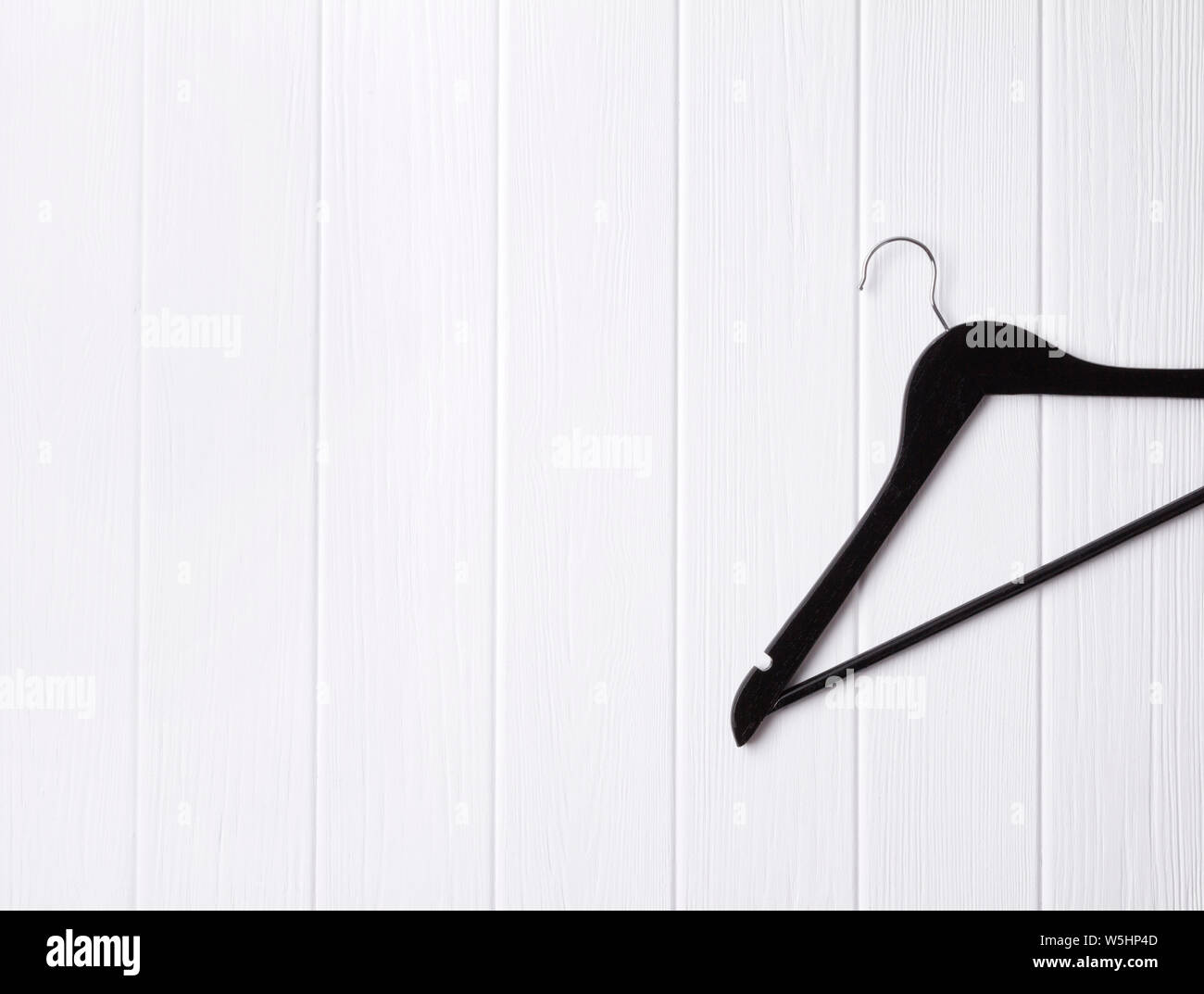 Top view flat lay single black wooden hanger at wooden background ...