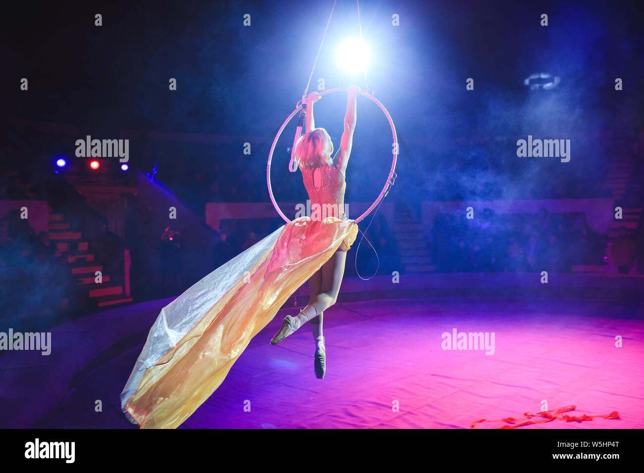 Aerial acrobat in the ring. A young girl performs the acrobatic ...