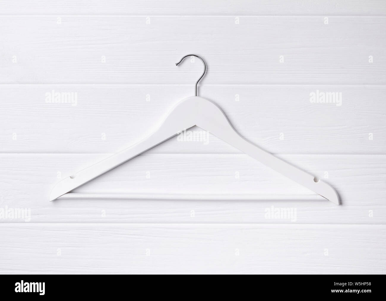 Top view flat lay single wooden hanger at white background. Fashion ...