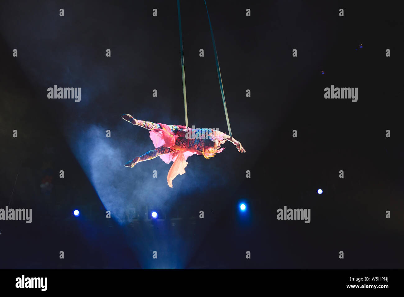 Aerial acrobat in the ring. A young girl performs the acrobatic ...
