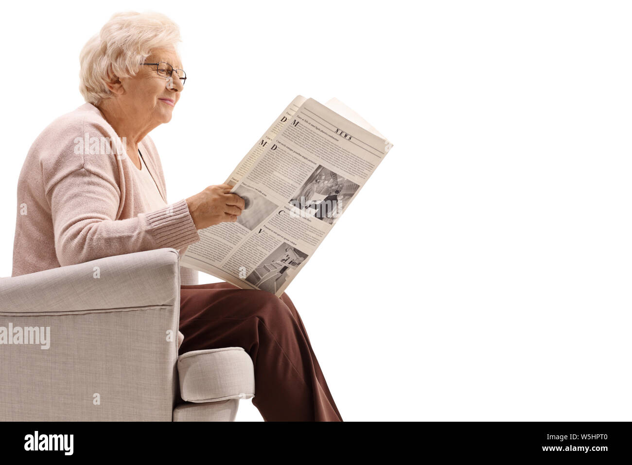 Profile shot of a senior woman sitting and reading a newspaper isolated ...
