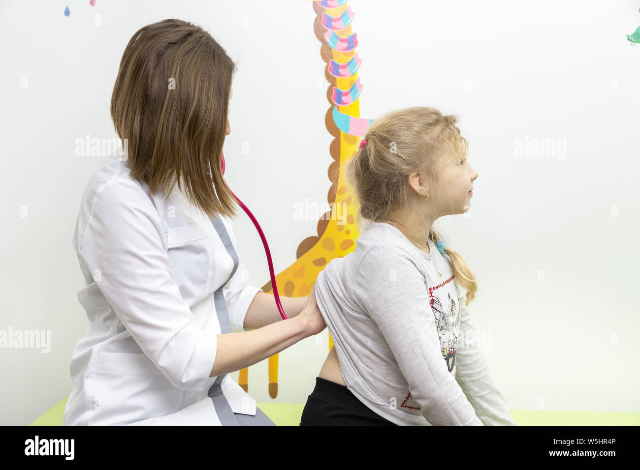 doctor listen with a stethoscope of a child. doctor puts a stethoscope ...