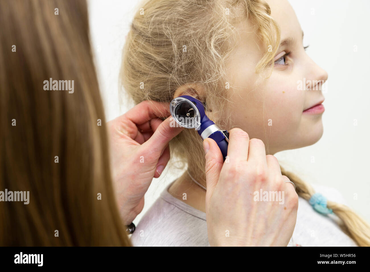 The doctor applies the otoscope to the ear. hearing test with a special ...
