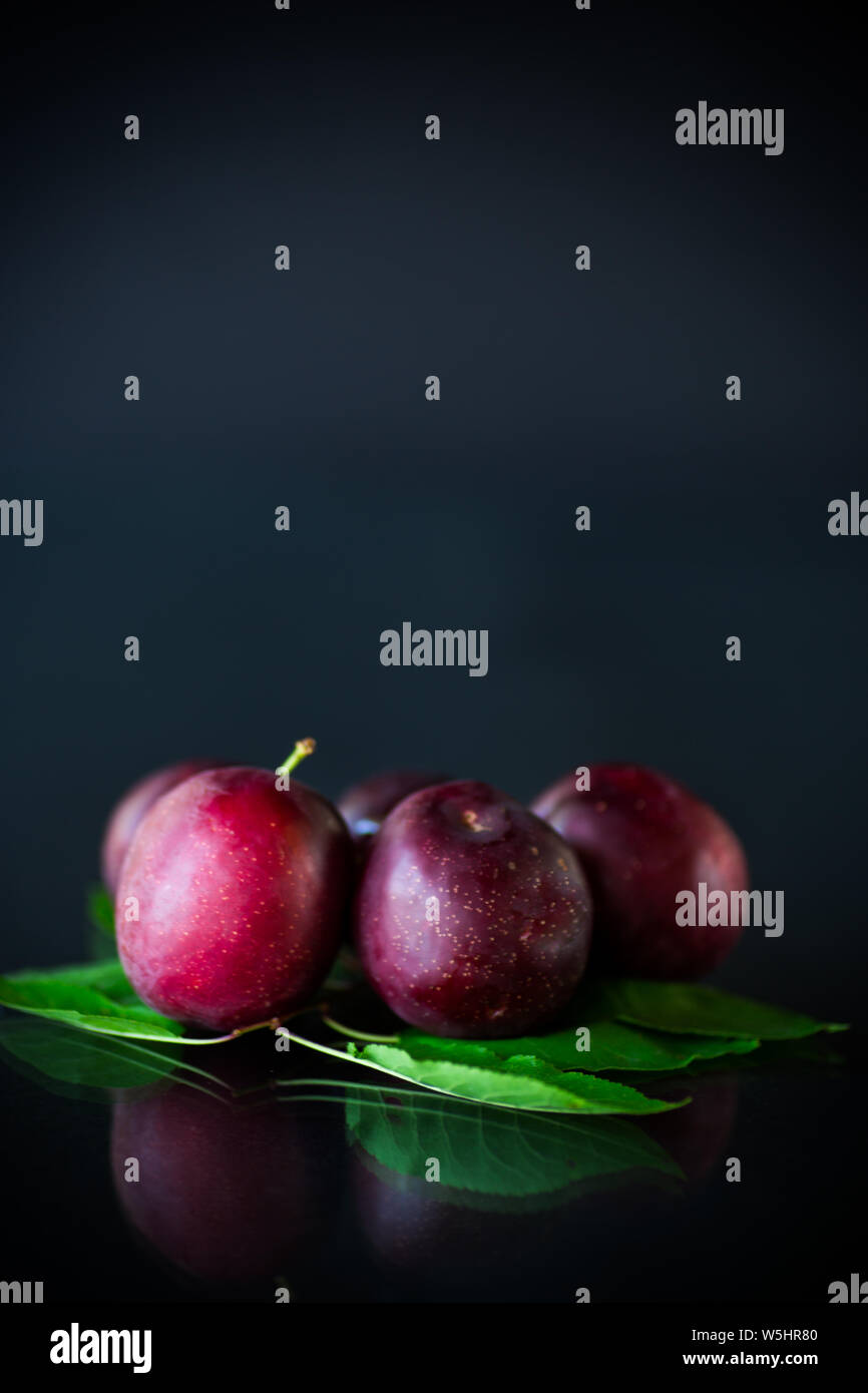 organic red ripe cherry plum isolated on black Stock Photo - Alamy