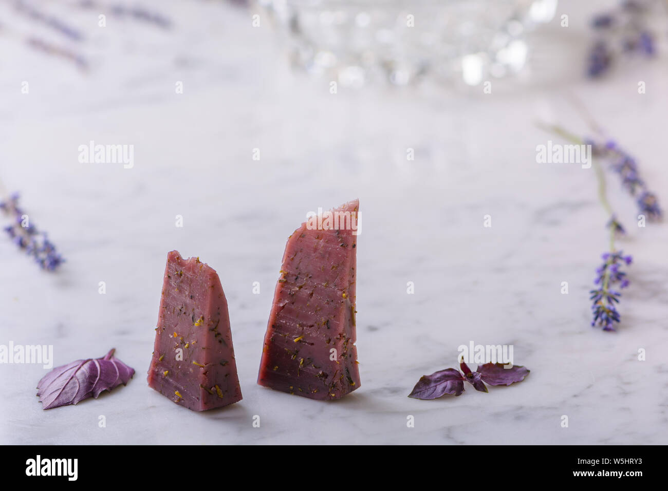 Two pieces of Basiron lavender cheese, lavender flowers and basil ...