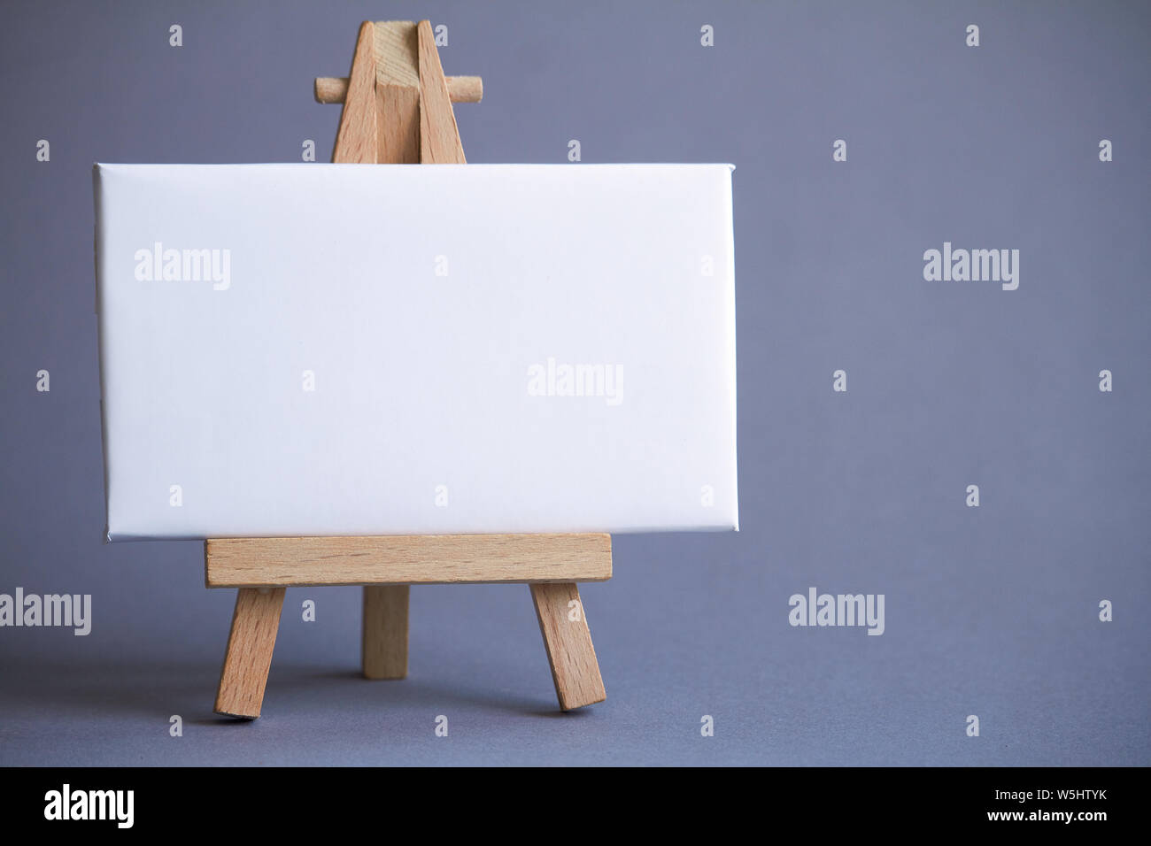 Miniature easel with a white board for writing, pointer on white ...