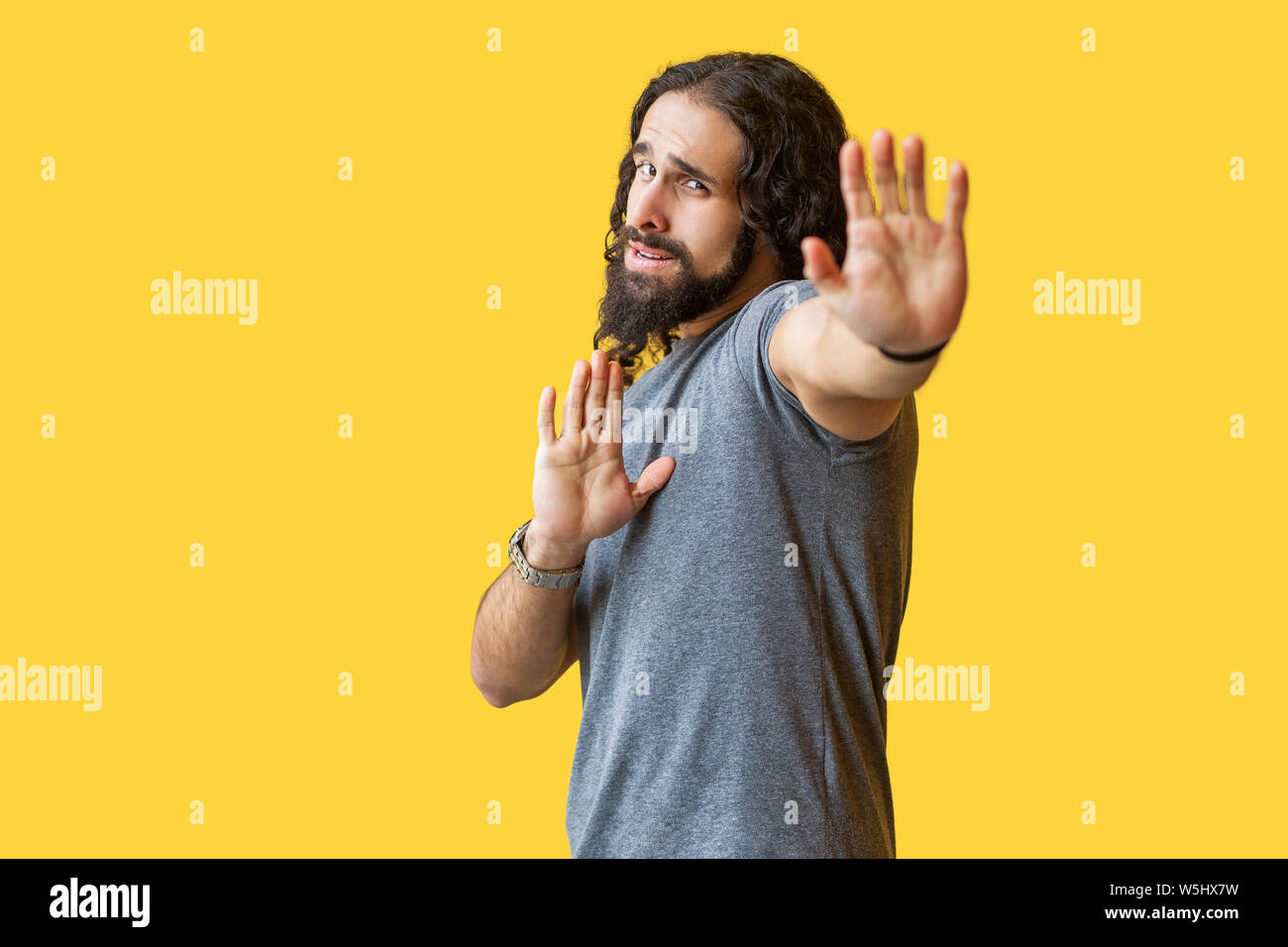 Stop. Portrait of scared or confused bearded young man with long curly ...