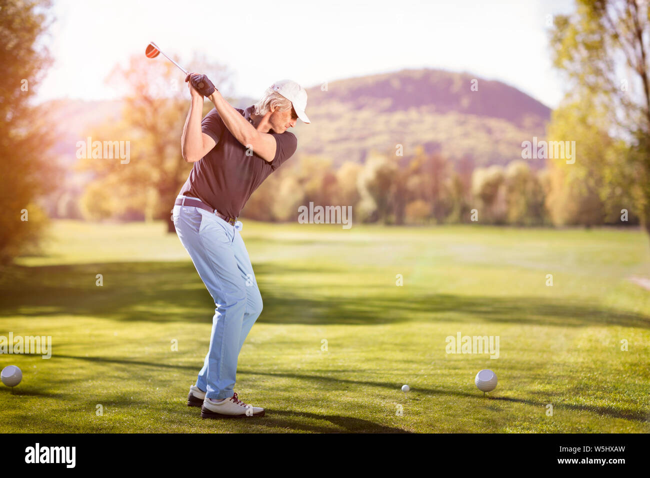 Old man swinging golf club Stock Photo - Alamy