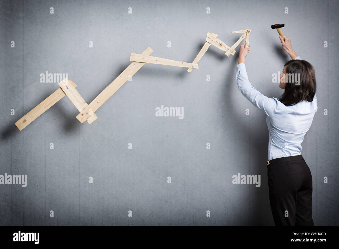 Young businesswoman building pointing up chart Stock Photo - Alamy