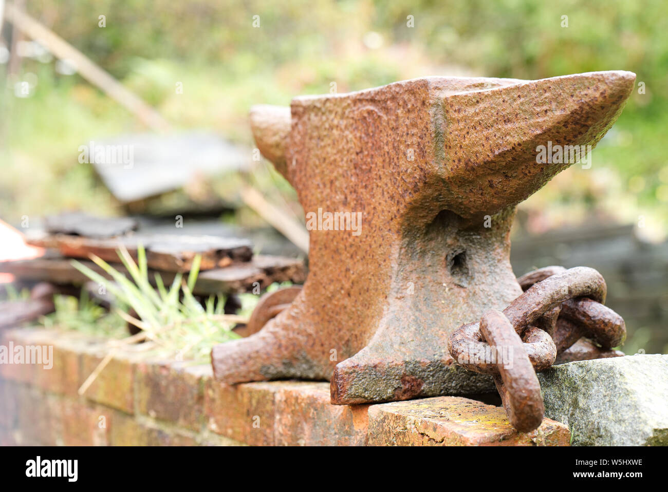 Rusty old blacksmith anvil with out of focus background Stock Photo - Alamy
