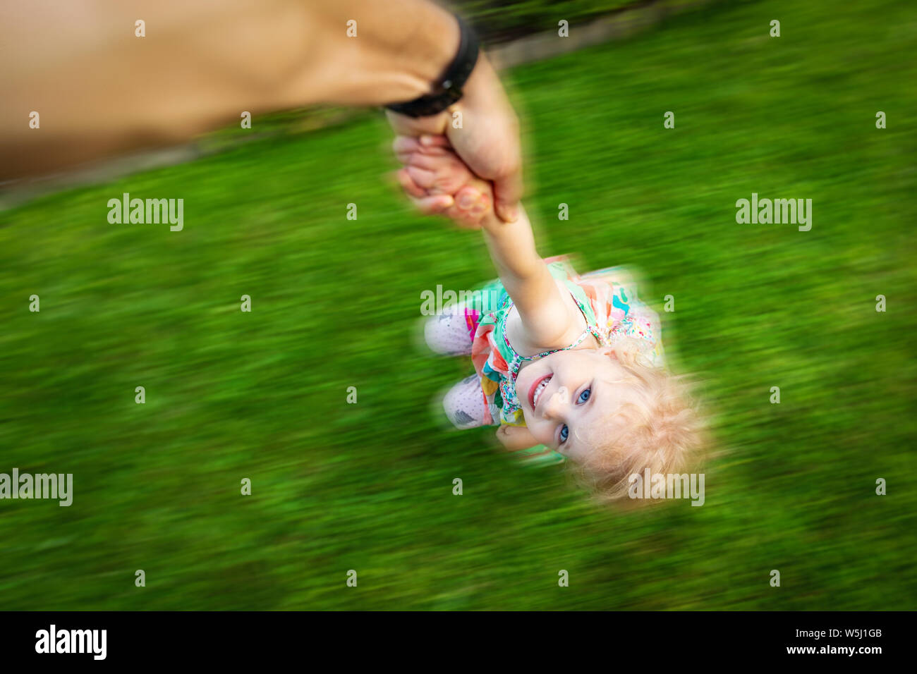 happy child is playing with parent at home. father holding his daughter ...