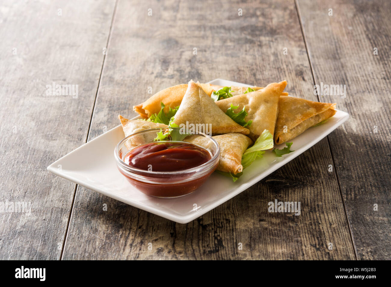 Samsa or samosas with meat and vegetables on wooden table. Traditional Indian food Stock Photo ...