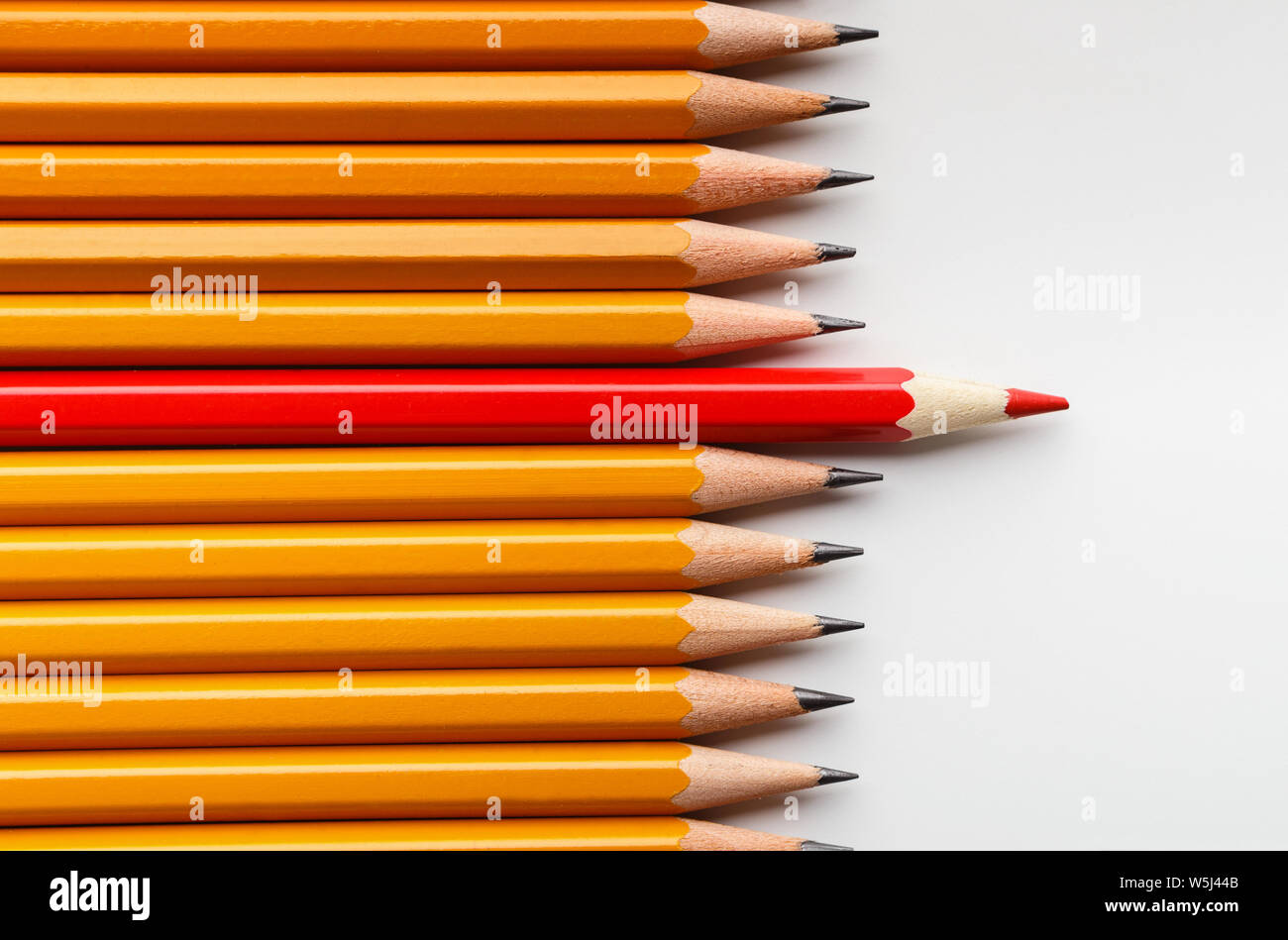 Red pencil standing between classic ones on white background Stock ...